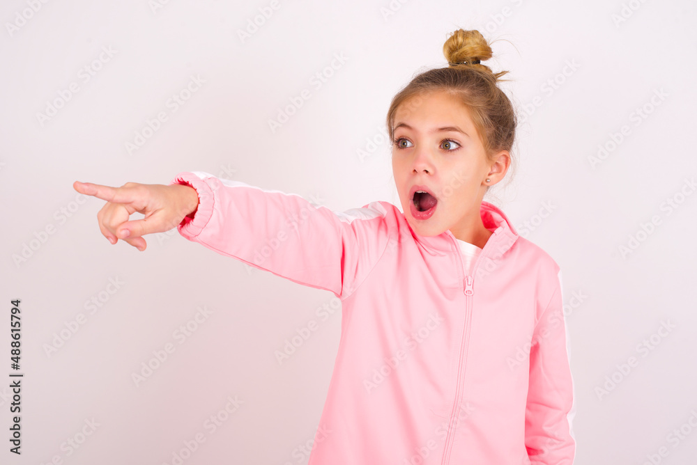 caucasian little kid girl with bun hairstyle wearing pink tracksuit ...