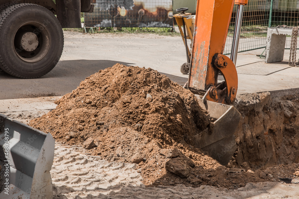Excavation works. Tractor bucket digging with a heavy shovel on the ...