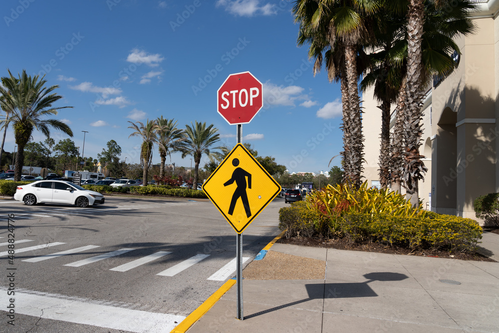 A stop sign with a Pedestrian Crossing Sign outside a shopping mall is ...