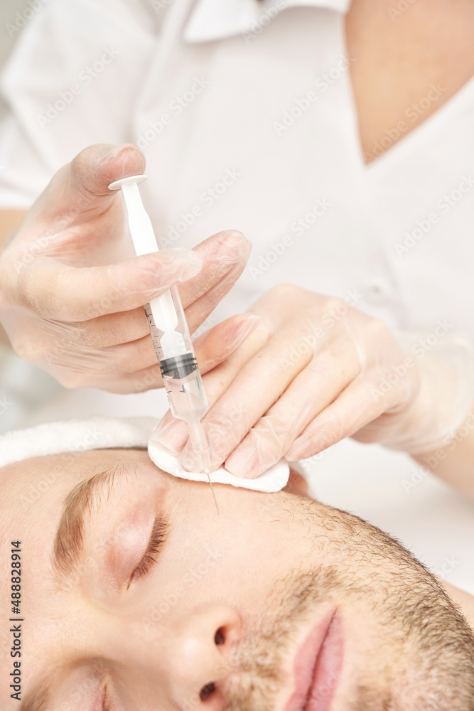 Injection at spa salon. Doctor hands in gloves. Closeup. Pretty male ...