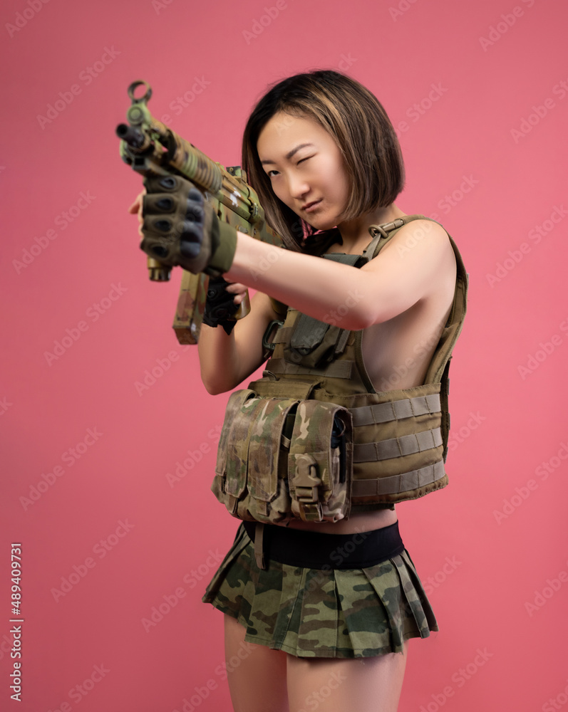sexy Asian woman in military clothes with an automatic rifle in her ...