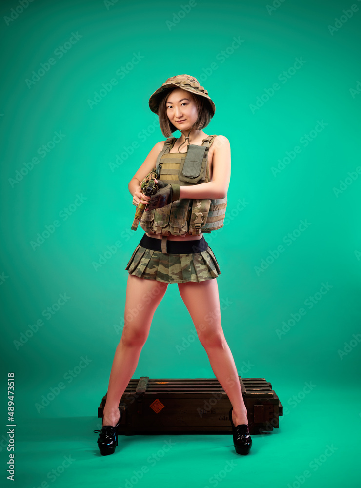 sexy Asian woman in military clothes with an automatic rifle in her ...