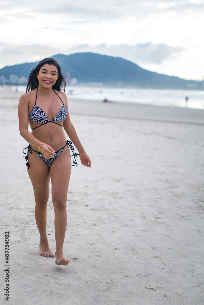 young beautiful and happy Asian Indonesian woman in bikini enjoying holidays at tropical beach ...