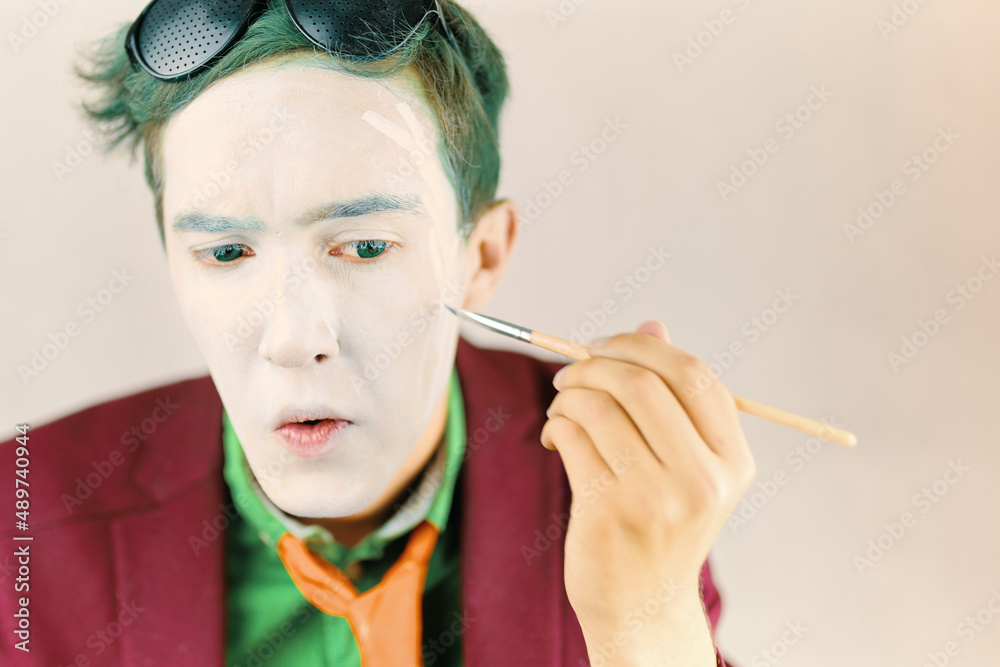 Mim is preparing for performance. Cosplayer paints his face with brush ...