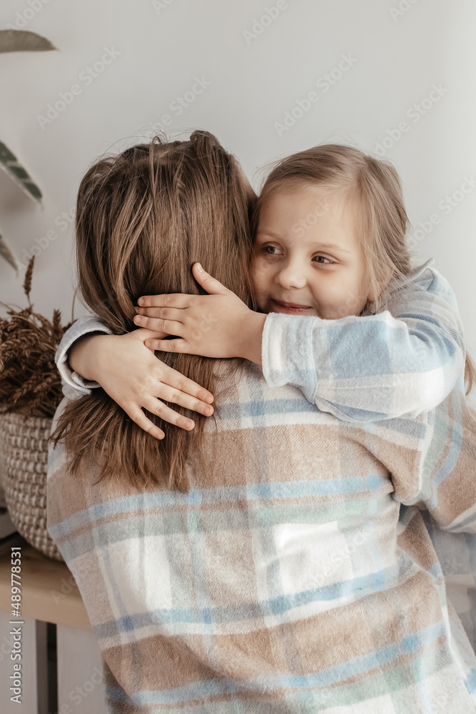 the daughter gently hugs her mother by the neck. the woman calms the ...