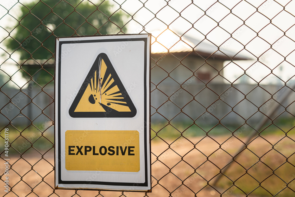 "Explosive" caution information metal sign plate on the wire fence ...