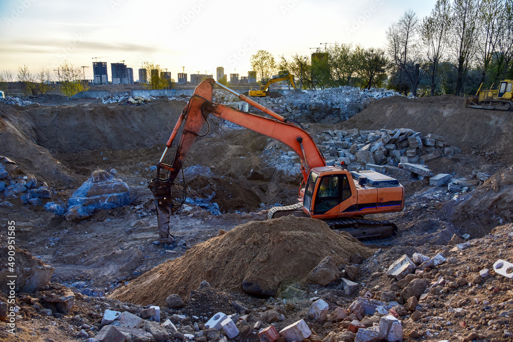 Excavator with hydraulic breaker hammer on destruction of concrete and ...