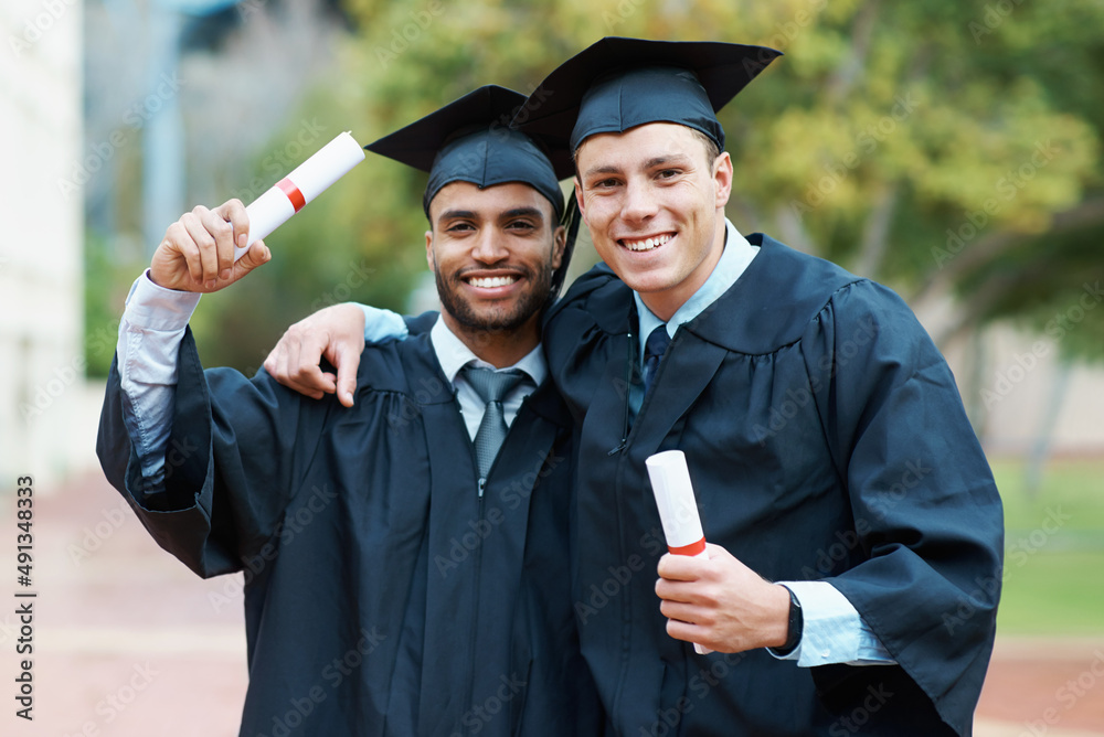 Were on our way to success. Two young college graduates holding their ...
