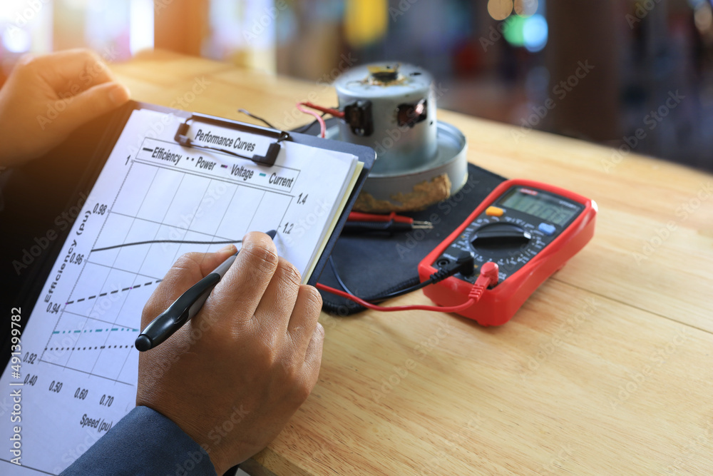 Technicians or staff are recording electrical test results of ...