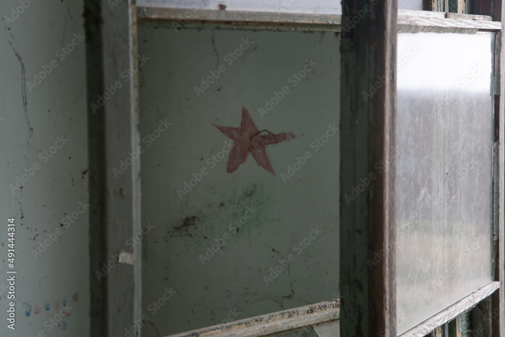 Red star as a symbol of communism on the wall in the demolished ...