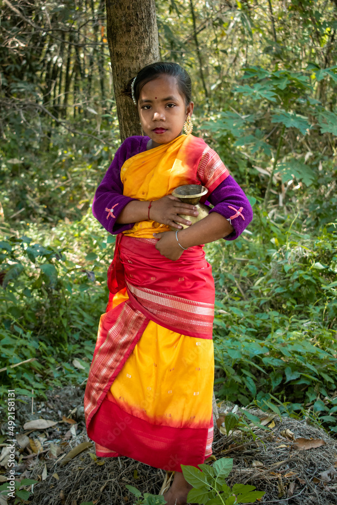A tribal Indian teenage girl is walking on the path of the forest alone ...