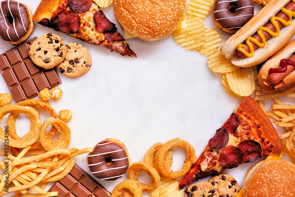 Junk food frame over a white marble background. Variety of take out and ...