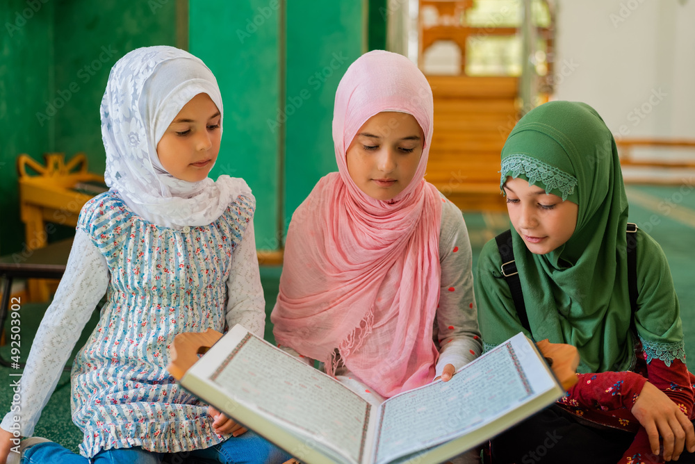 Group of a children reading a holy book Quran in the mosque. Happy ...