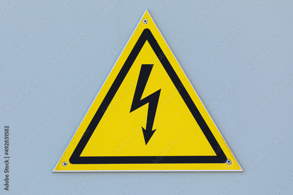 Black caution or warning electrical triangle sign or table on yellow ...