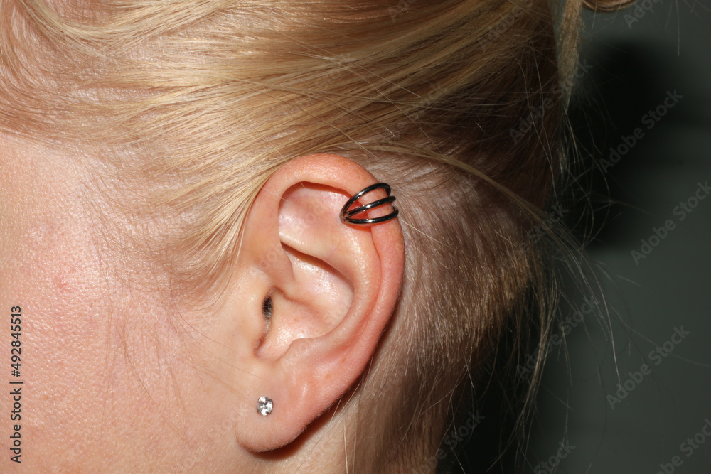 Girl's ear. Ear cartilage piercing + triple ring. Ear lobe piercing ...