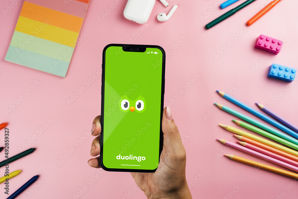 Girl holding a smartphone with Duolingo language-learning app on the ...