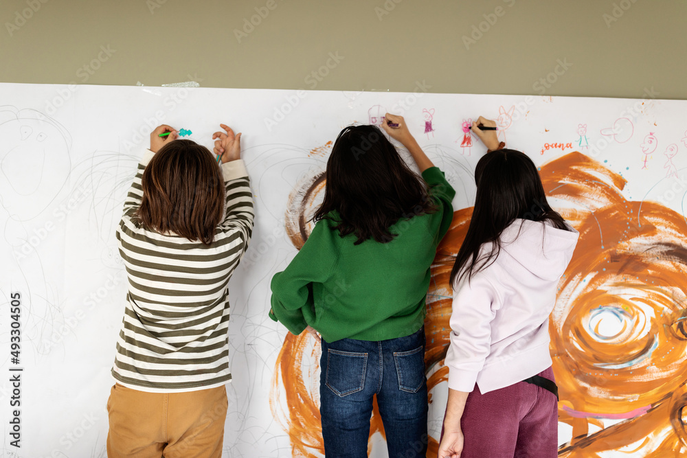 Children drawing on wallpapered wall Stock Photo | Adobe Stock