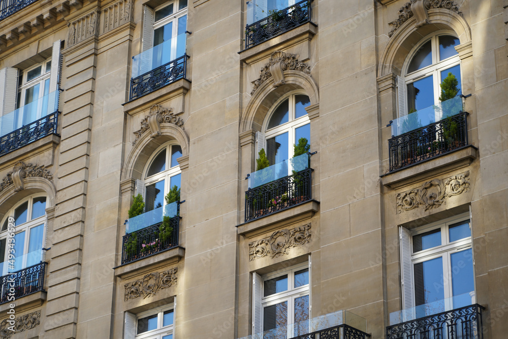 Beautiful facade of a building from Paris, France, with a lot of plants ...