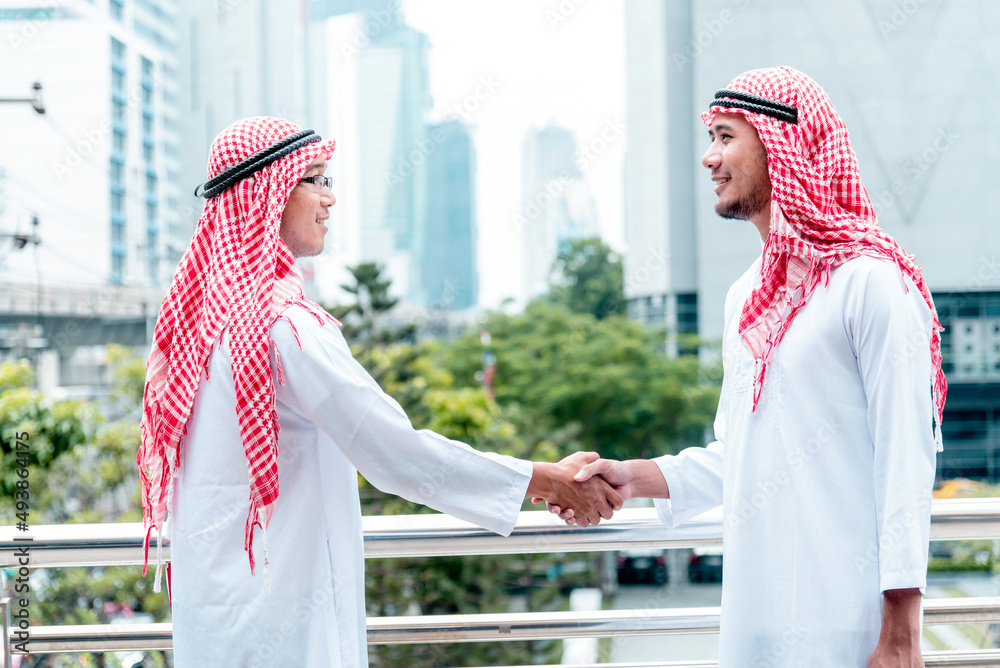 Photo Stock Arab Businessman Muslim dress shaking hands together in ...