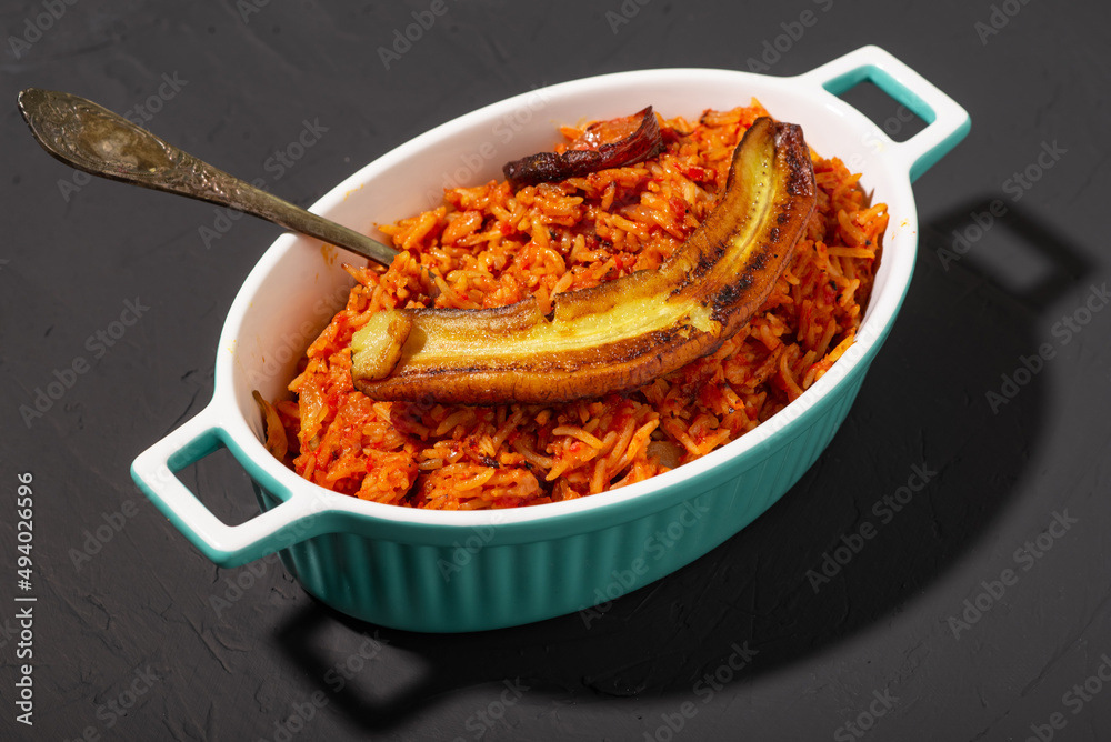 Jollof rice with fried banana. Traditional Nigerian rice food with ...