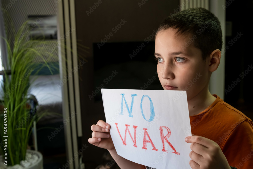 Crying boy asks to stop the war. The child holds a poster. A child ...
