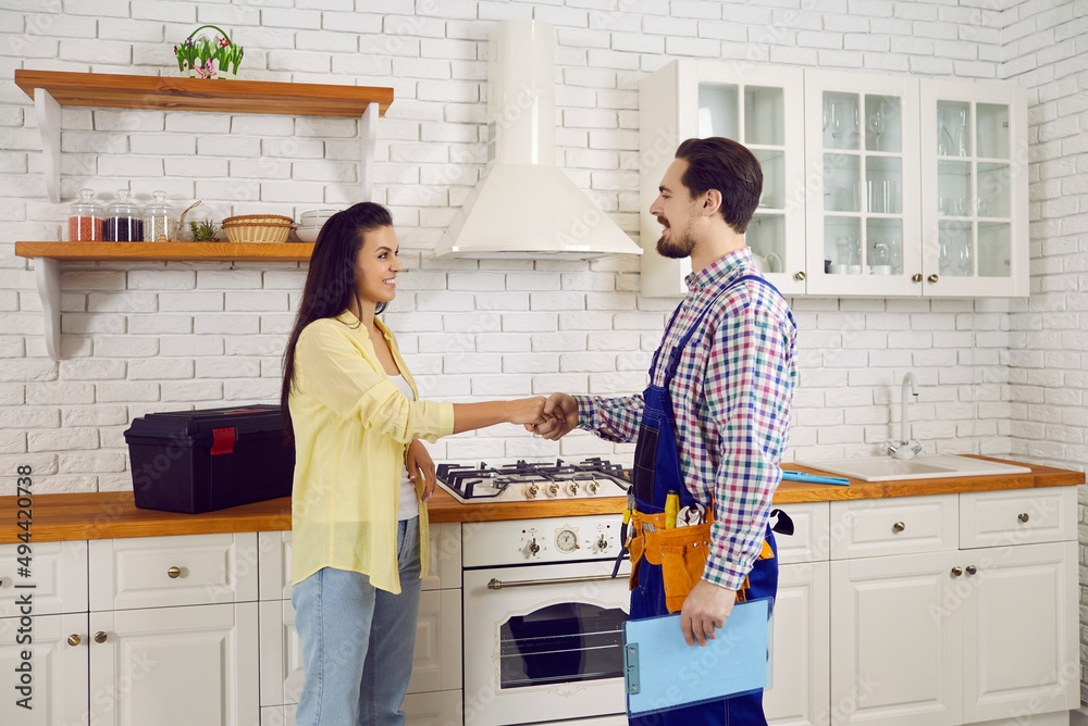 Smiling male plumber shake hand of happy female client or customer ...