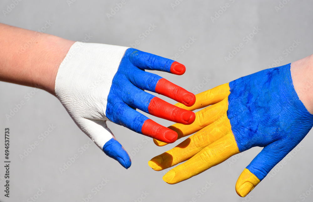 hands of russian and ukrainian flags colors, symbol of truce and ...