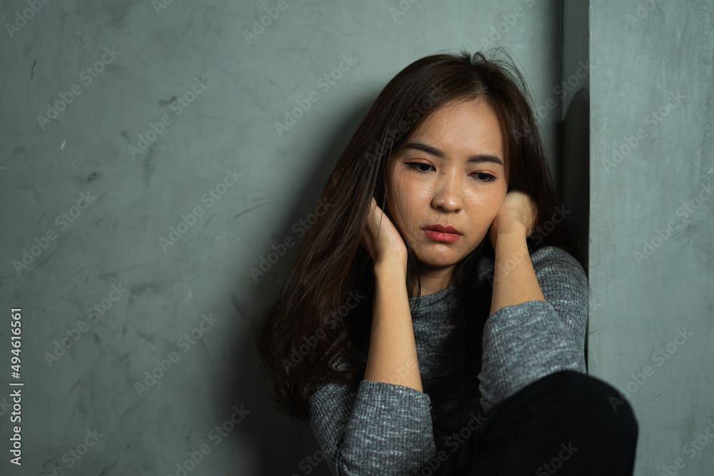 Young woman sitting sad against pole, catch head, depression emotion ...
