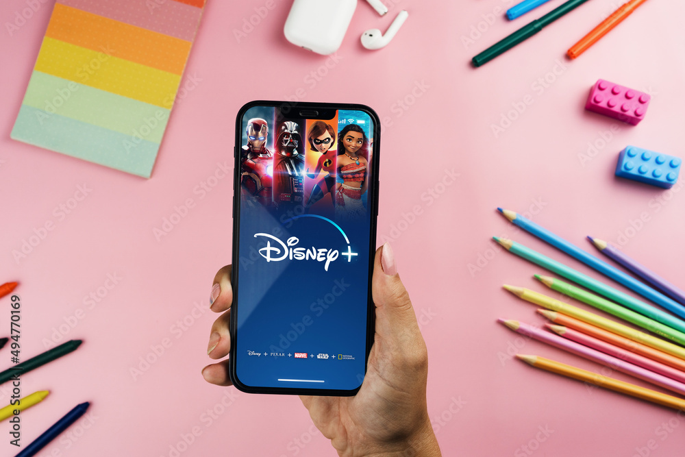 Girl holding a smartphone with Disney+ (Disney Plus) app on the screen ...