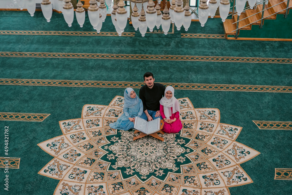Happy Muslim family reading a holy book Quran. Father teaching child ...