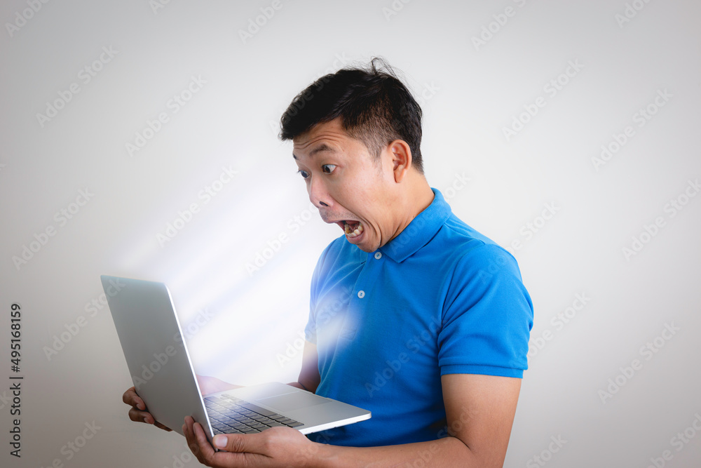 young man was shocked to see a computer laptop with worried eyes and ...