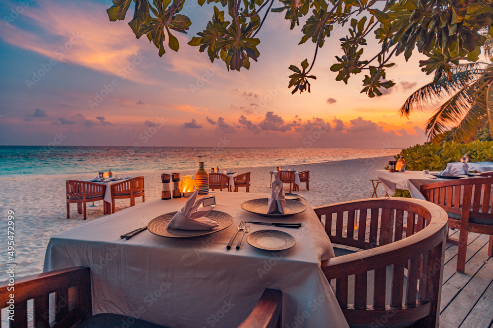 Romantic sunset on tropical island shore. Dinner table in beach ...