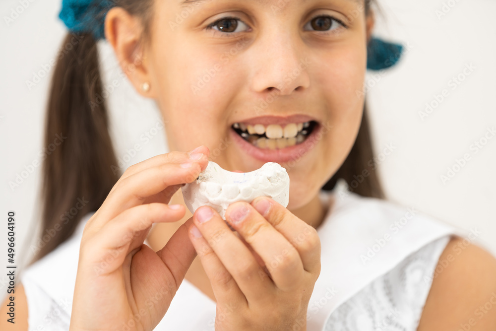 Teenager is holding a dental cast model at the start of orthodontic ...