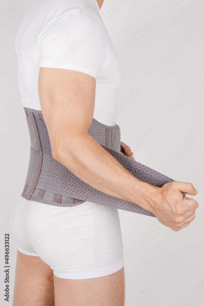 Lumbar brace on the human body isolated on a white background. Trauma ...