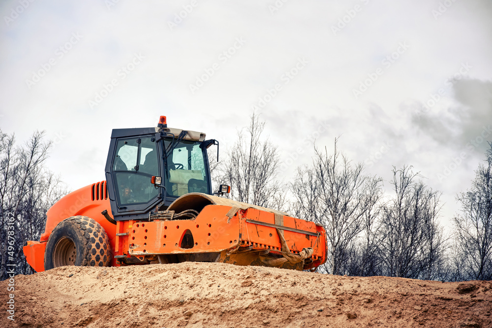 Soil compactor with smooth drum on the hill, road construction ...