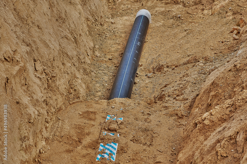 Construction of a water fence. The plastic water pipe lies in the ...