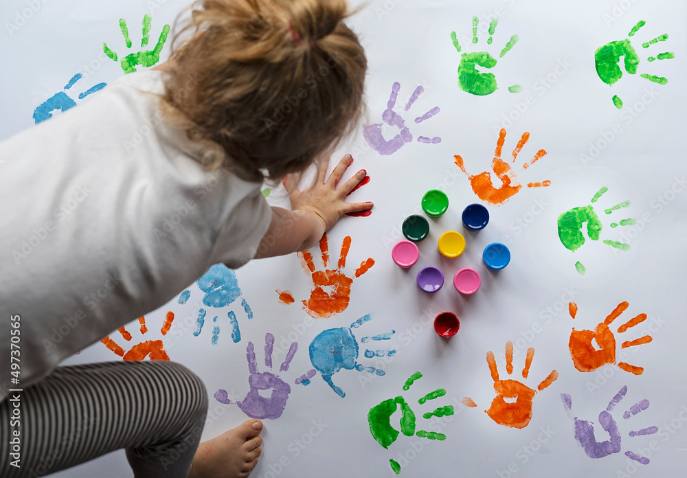 Handprint and footprint imprint by child in diffrent colors on white ...