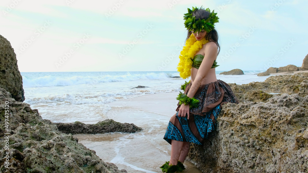 Woman rests and poses happily on the beach wearing the typical hula ...