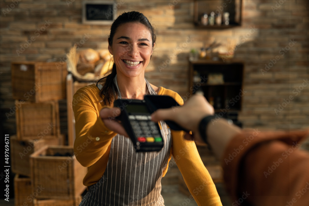 Cinematic shot of young friendly saleswoman passing pos terminal over ...
