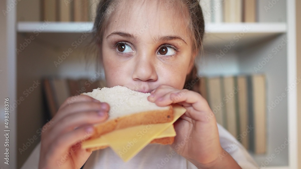 schoolgirl eats a sandwich at school during recess with backpack and ...