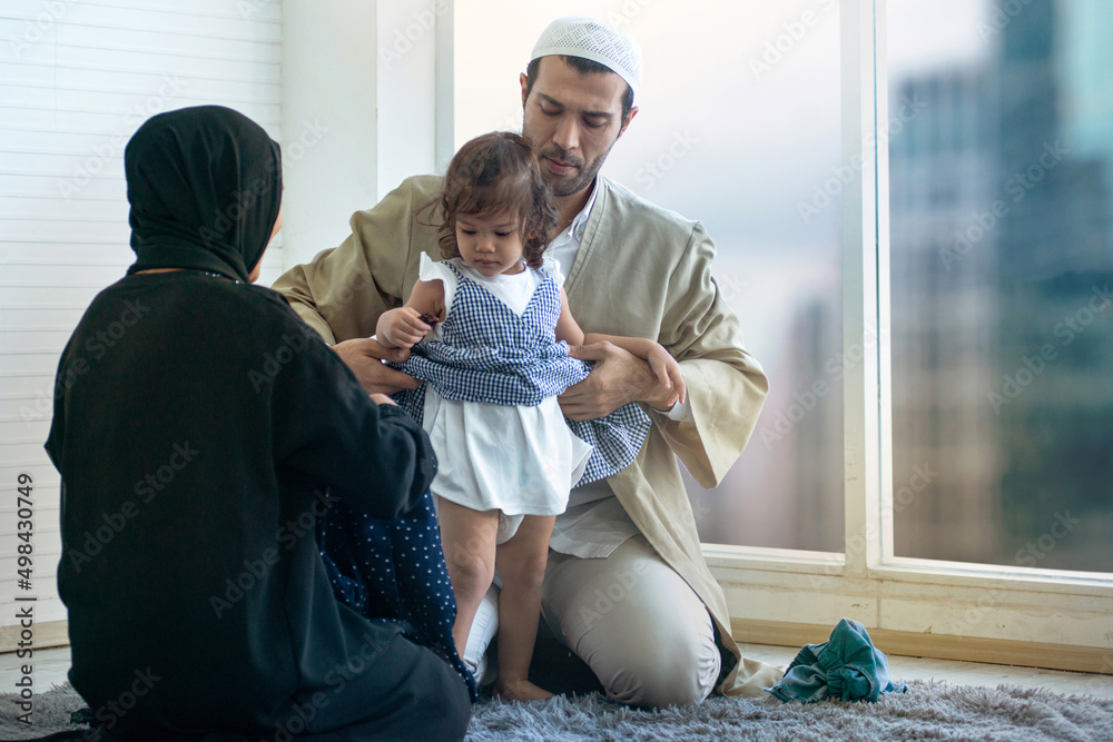 Foto Muslim father and mother in traditional dress helping dressing ...
