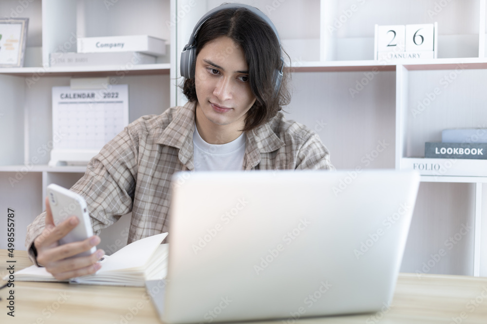 Young student does his homework and is broadcast live on his laptop ...