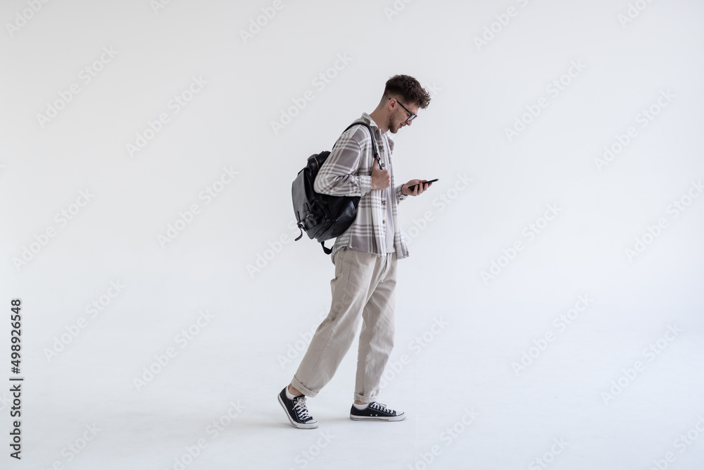 Foto de Stock Side view portrait of a student walking with bag and ...