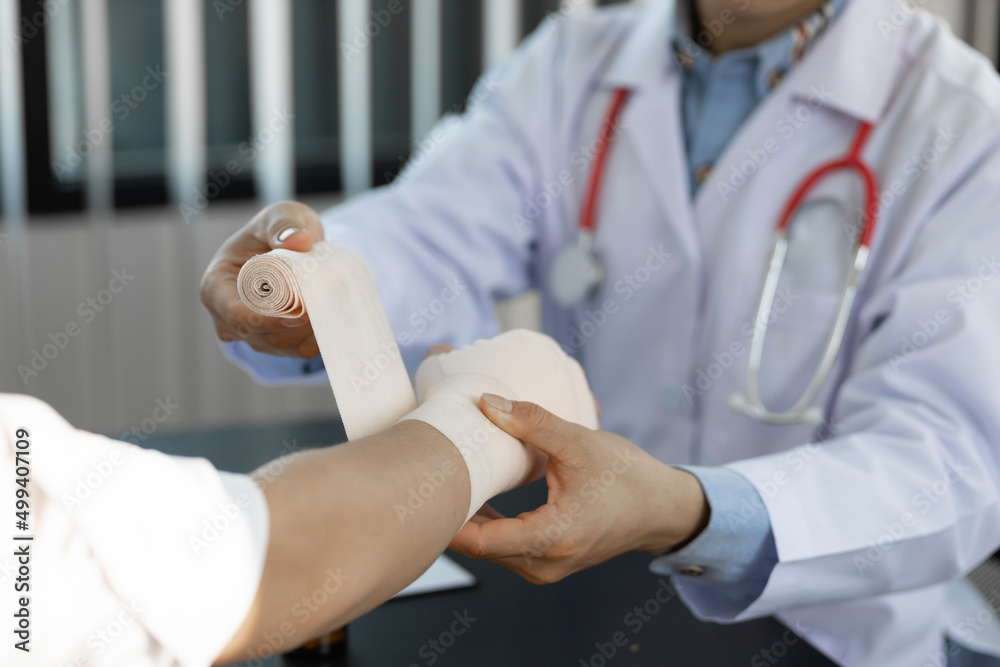 First aid concepts and wrist injury treatment. Doctor wrapped around ...