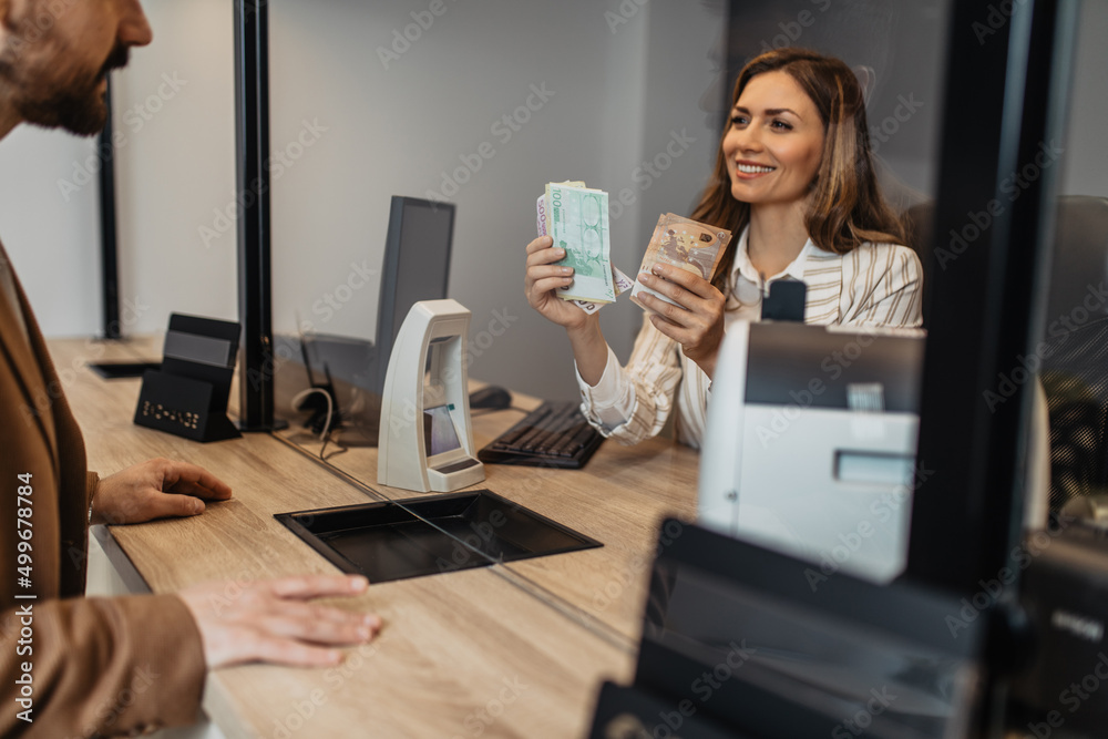 Attractive European businesswoman working in exchange office. She is ...