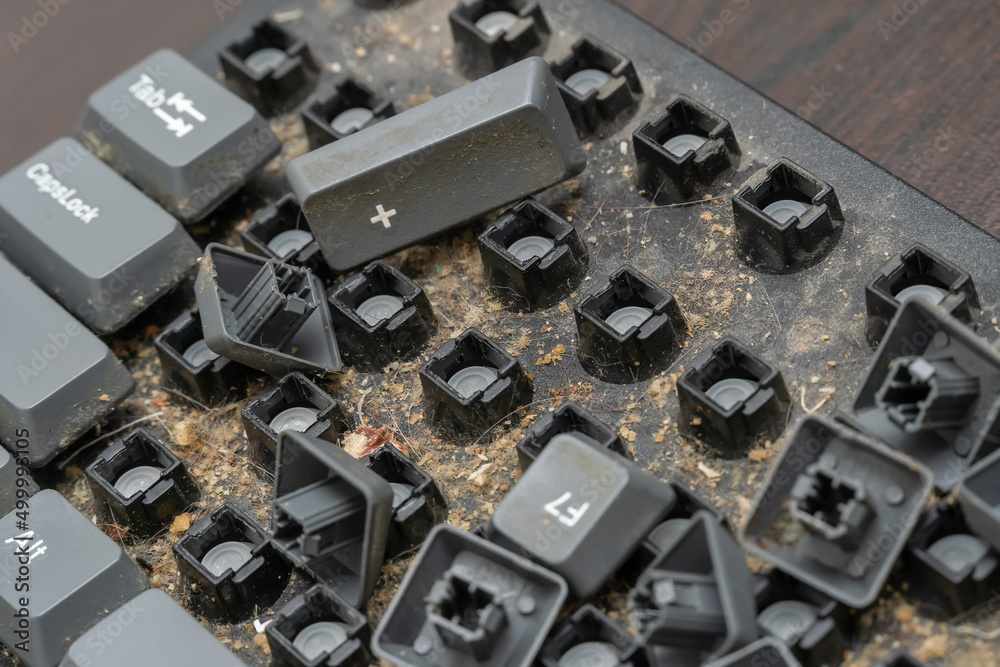 Close-up of a very dirty disassembled computer keyboard on the table ...