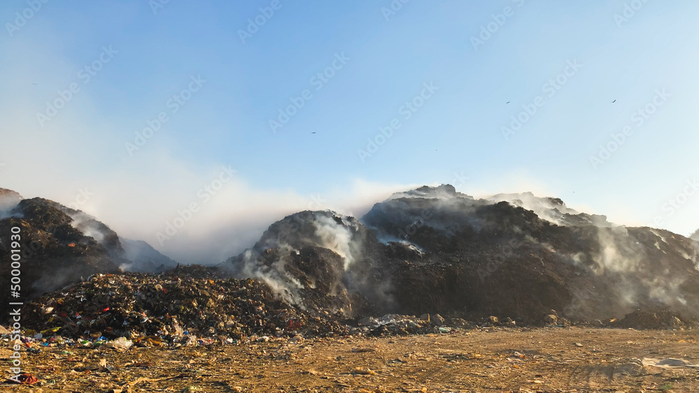 Burning pile of garbage at dump ground or landfill releasing toxic ...