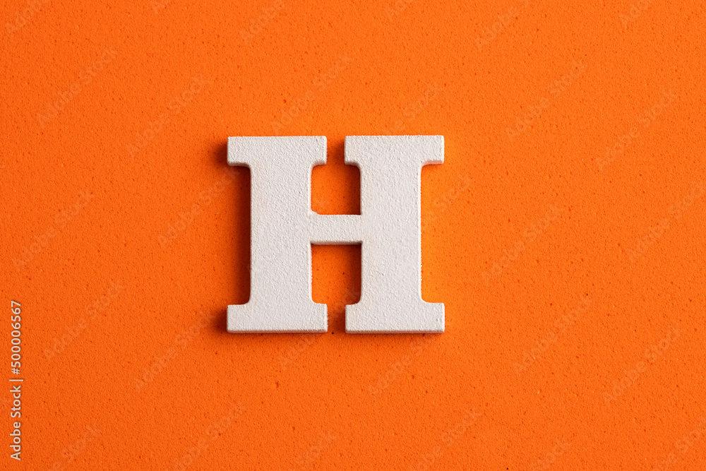 White wooden capital letter H on orange foamy background Stock Photo ...