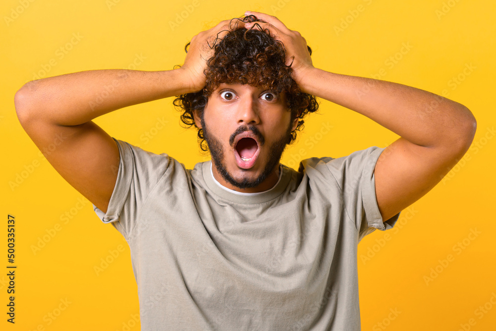 Excited shocked Indian man holding hands on head and screaming looking ...