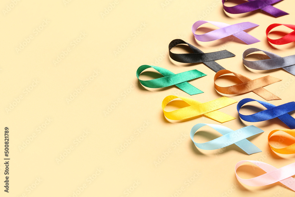 Colorful awareness ribbons on beige background. World Cancer Day ...